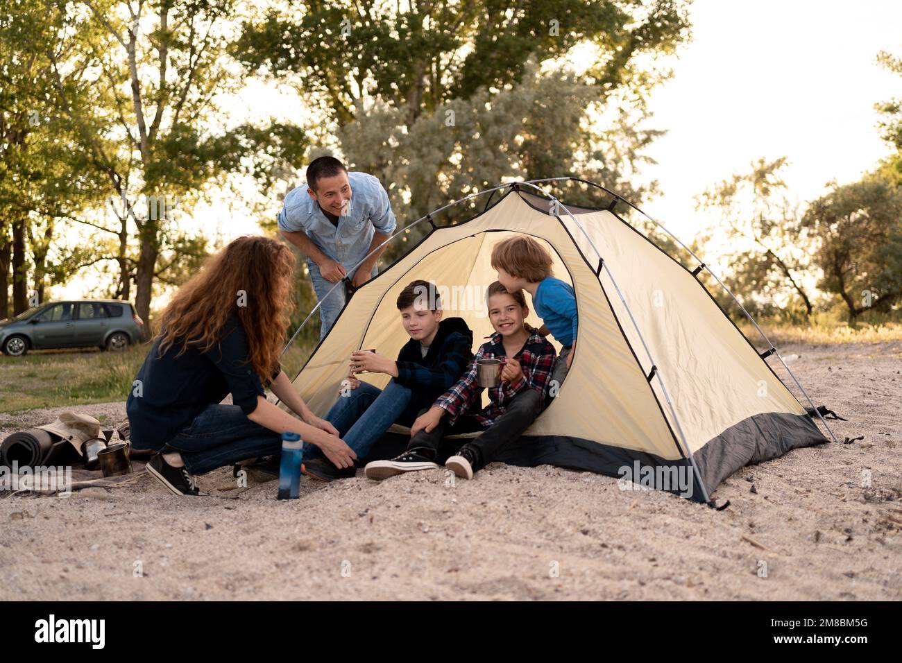Family interacting outside the tent at campsite. happy big family ...