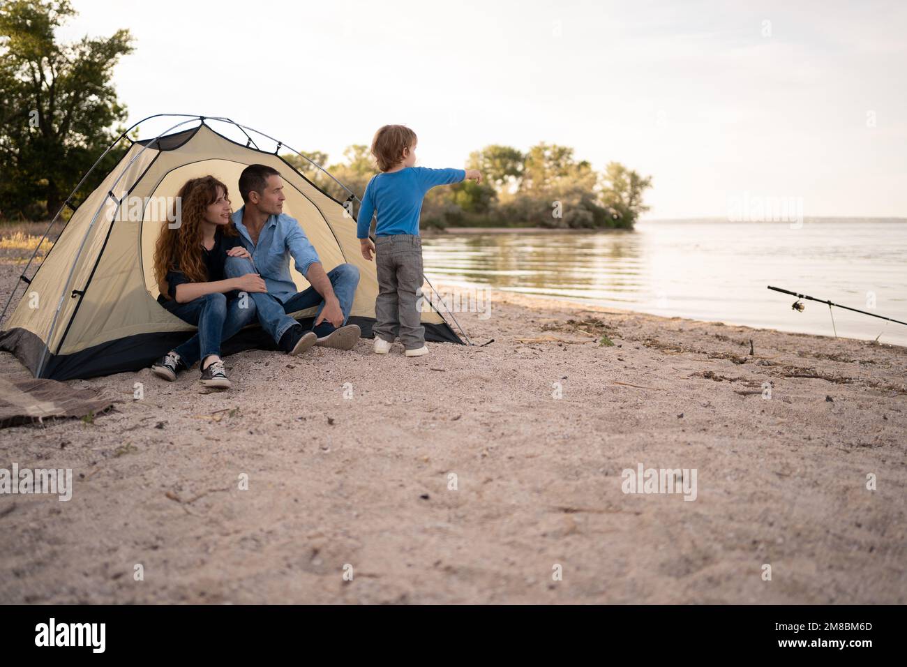 happy family in the tent at camp site pointing finger to something ...
