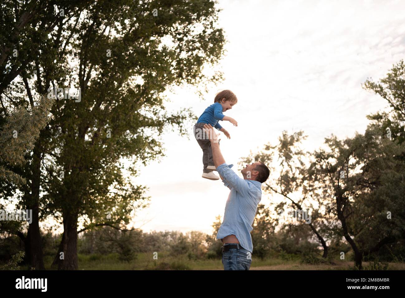 Happy joyful child, father fun throws up son in the air, carefree ...