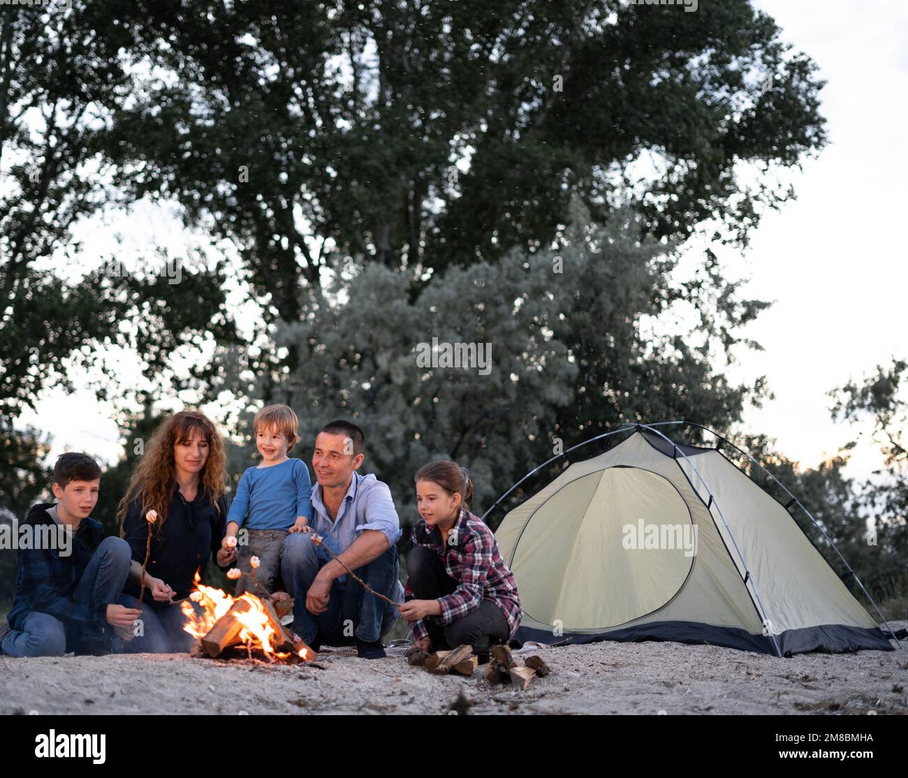 Family sitting around fire hi-res stock photography and images - Alamy