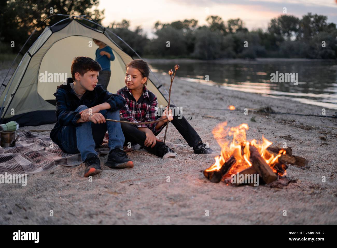 Family bonfire in nature near tent.Two kids camping. Bbq marshmallow ...