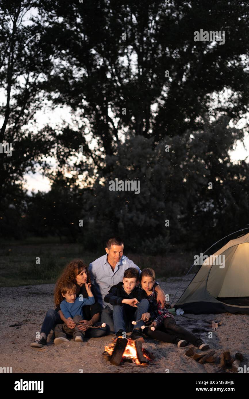 Family bonfire in mountain forest. Five people camping. Bbq marshmallow ...