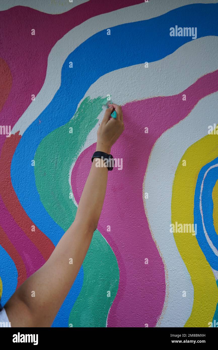 wall painting, Beautiful woman painting the wall colorfully Stock Photo ...