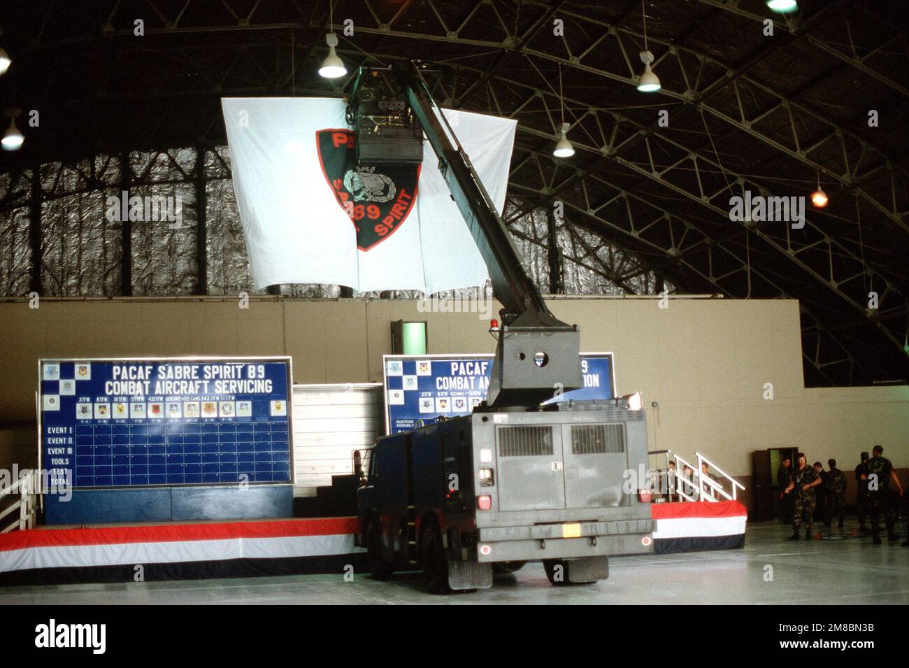 The Sabre Spirit '89 banner is raised above the scoreboards in Hangar 4 ...
