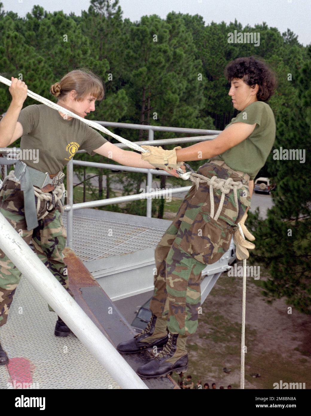 Fourth Battalion women recruits practice rappelling from a tower. The ...