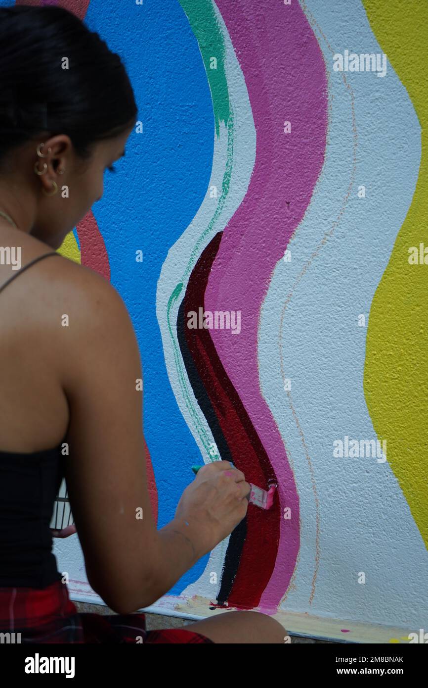 wall painting, Beautiful woman painting the wall colorfully Stock Photo ...
