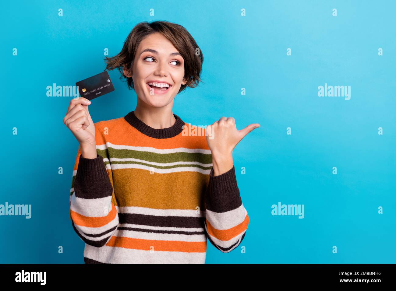 Photo of funny dreamy lady wear striped sweater holding bank card ...