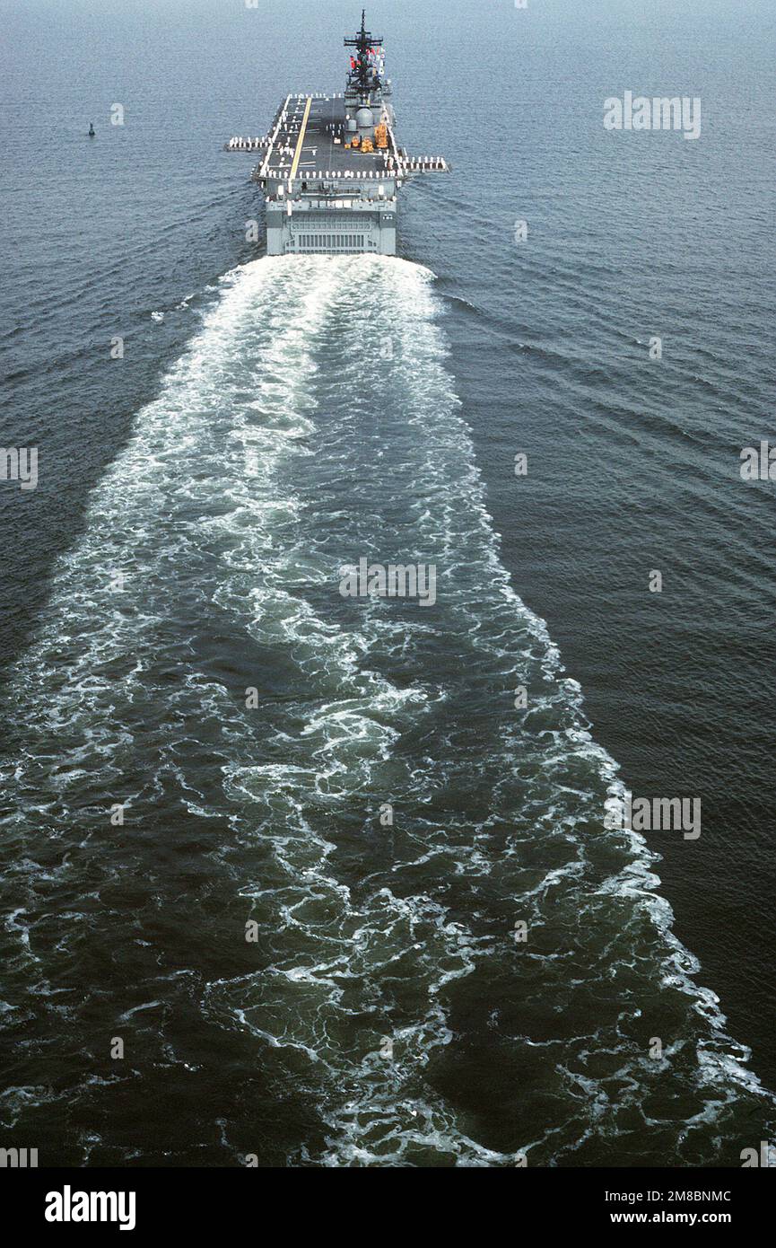 An aerial stern view of crewmen manning the rails on the amphibious ...