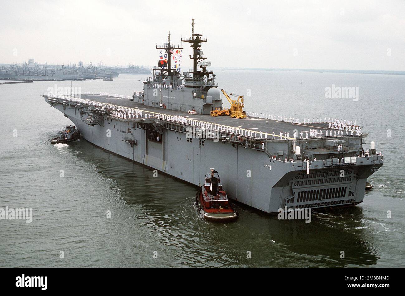 Large harbor tugs maneuver the amphibious assault ship USS WASP (LHD-1 ...