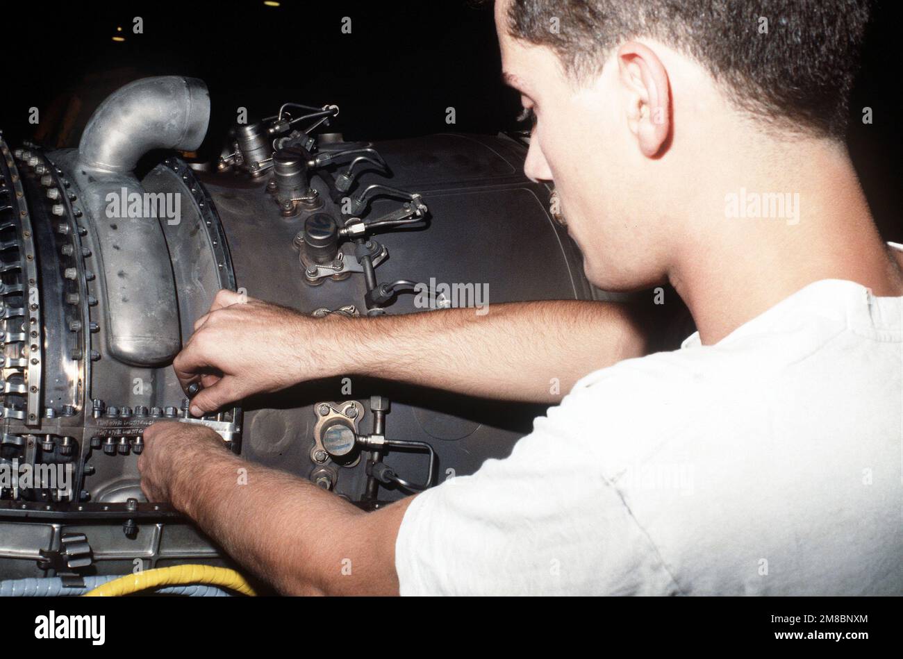 An aviation machinist's mate airman takes apart a turbine engine ...