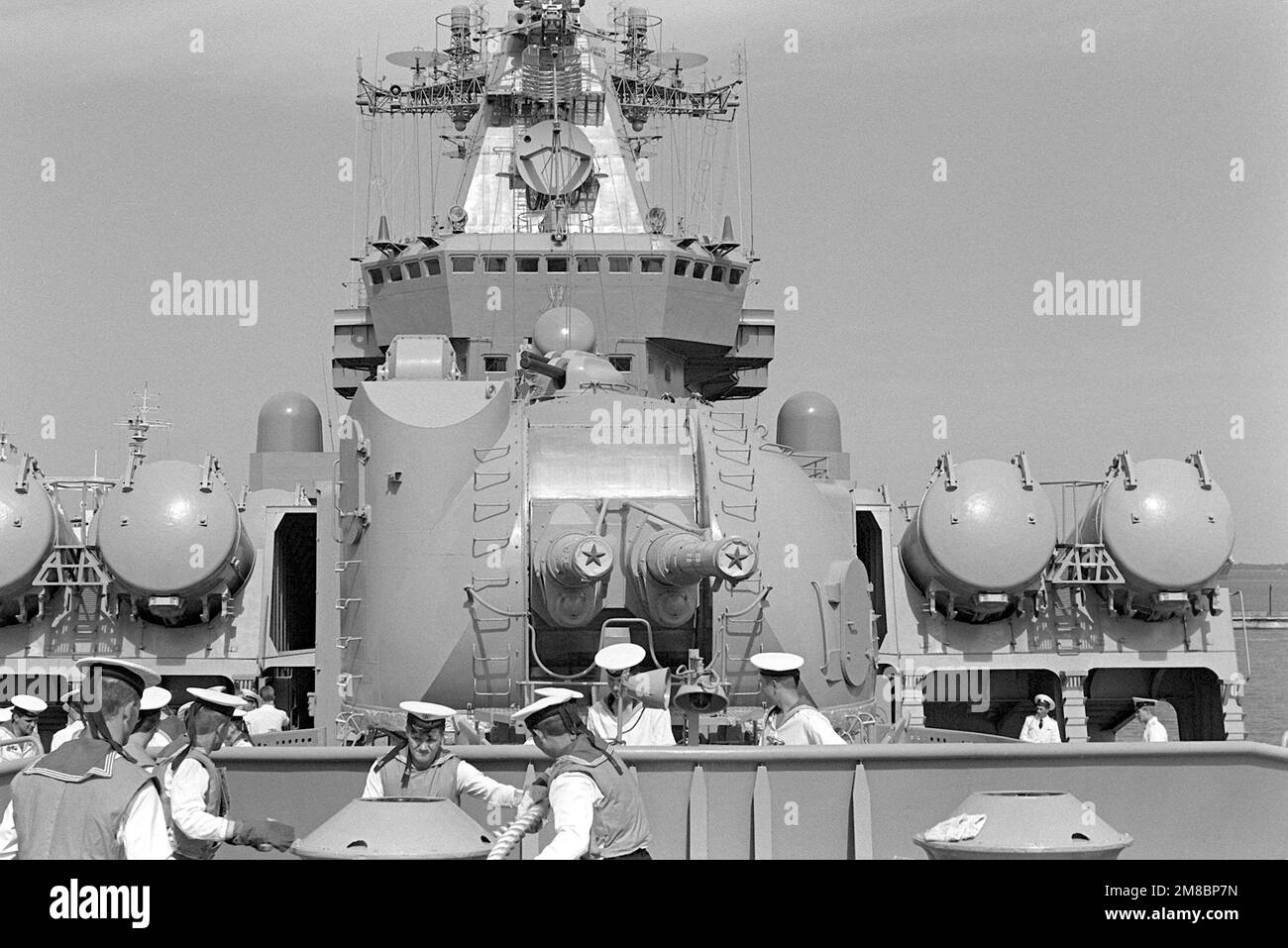 Soviet sailors handle a line on the bow of the Soviet Slava class ...