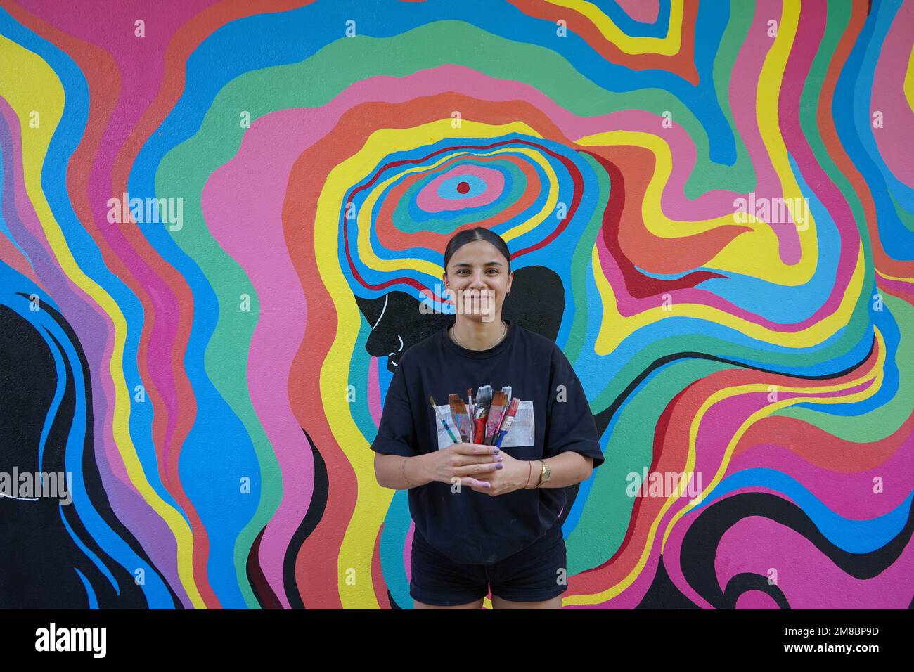 wall painting, Beautiful woman painting the wall colorfully Stock Photo ...