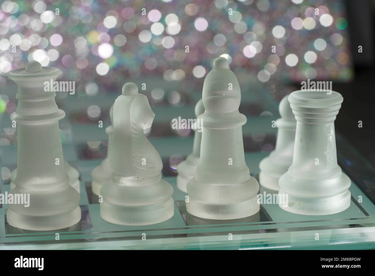 Chess with game pieces made of glass, queen, king, pawn and game board ...