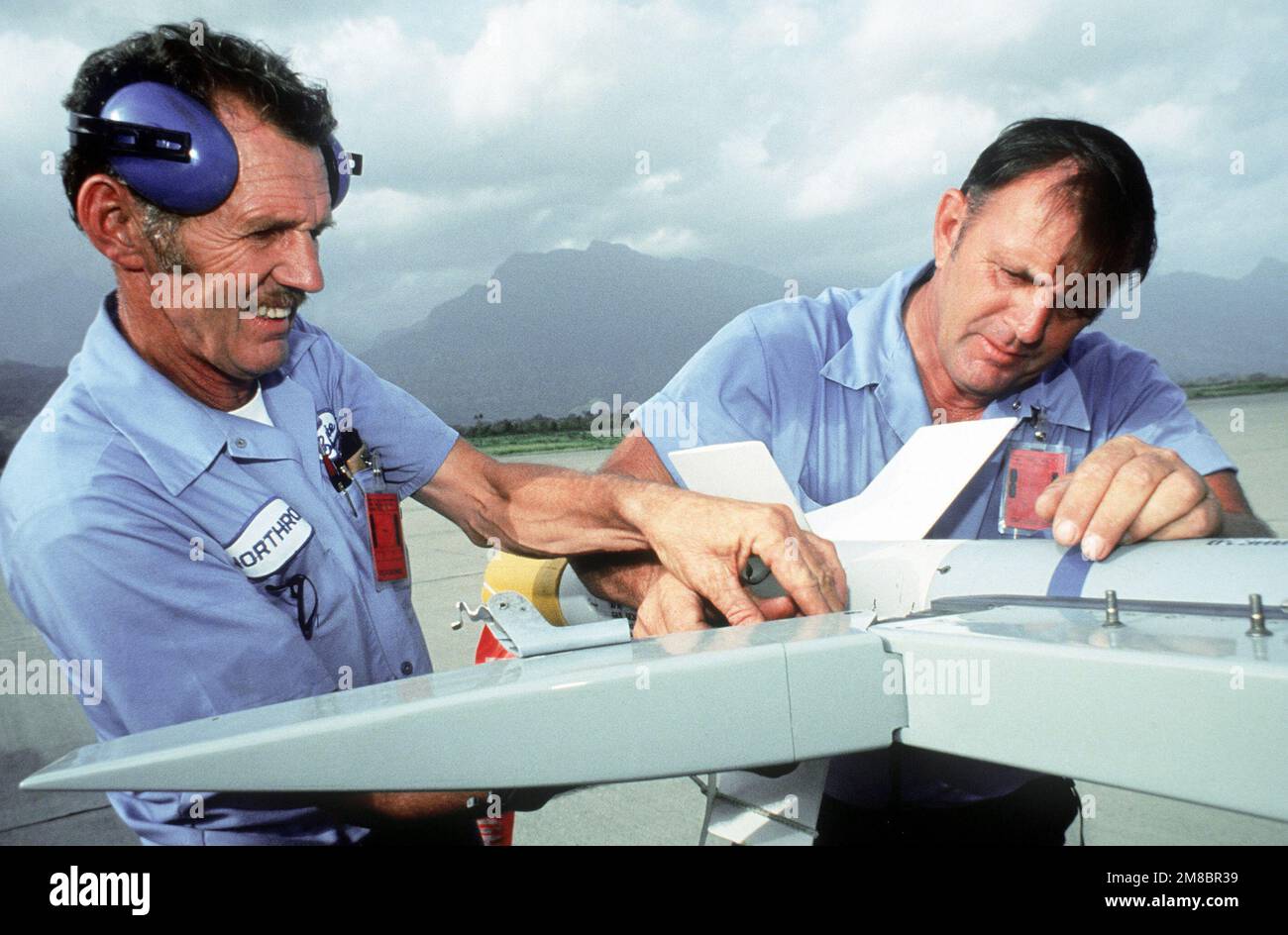Civilian technicians from Northrop, the aircraft's manufacturer, adjust ...