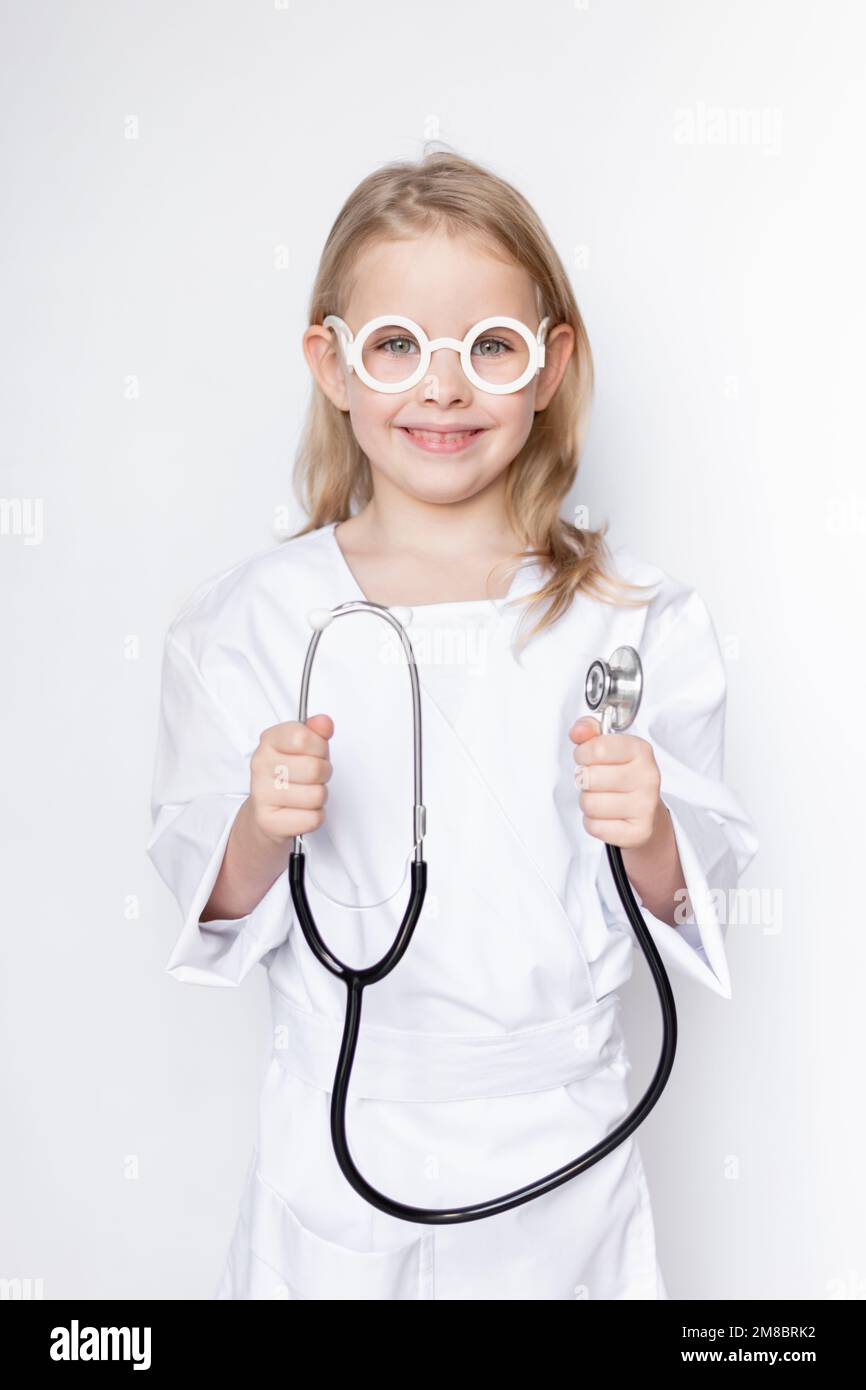 Portrait of cute little girl dressed up in doctor attire with toy ...