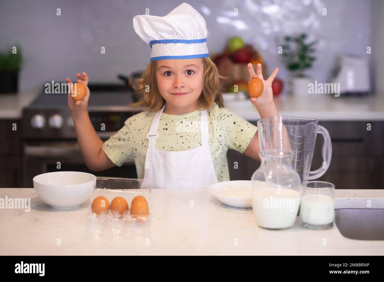 Kid chef cook with eggs at kitchen. Kid chef cook cookery. Cooking ...