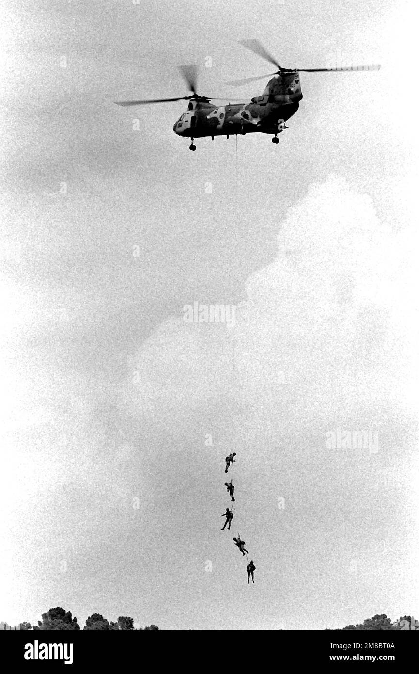 Marines are suspended underneath a CH-46E Knight helicopter during a ...