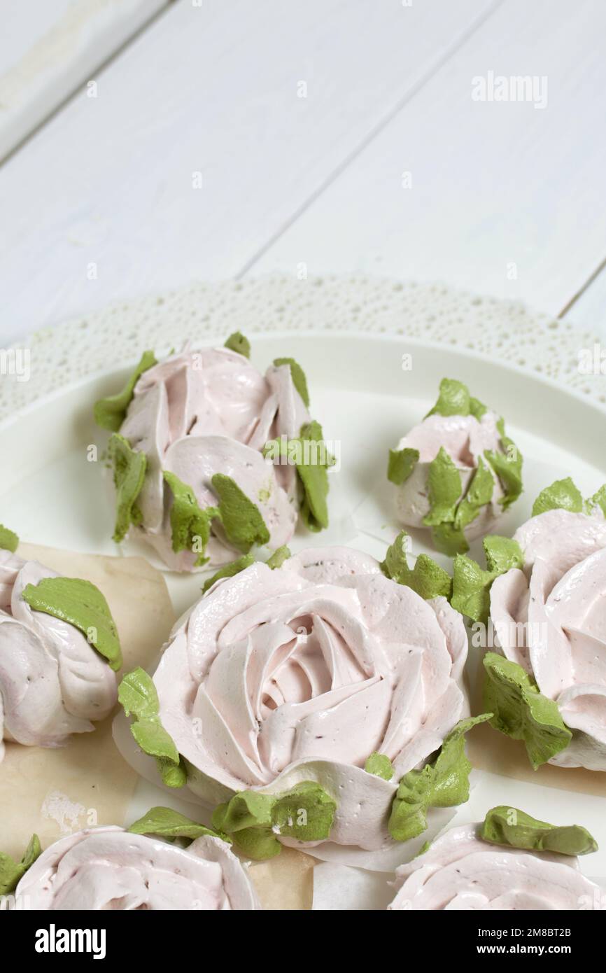 Homemade zephyr roses dry on a tray. On a white background. Close-up ...