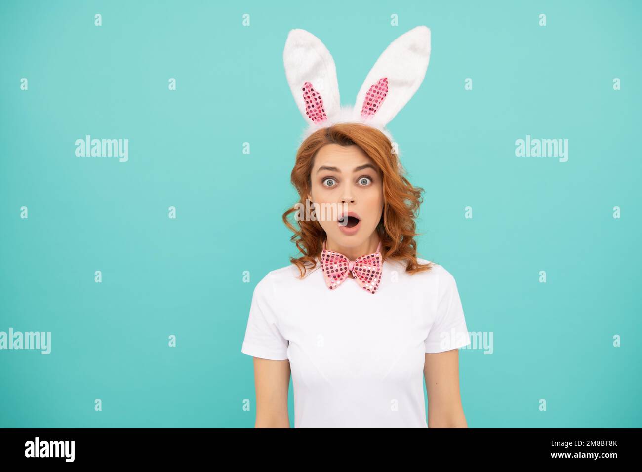 shocked easter woman with bunny ears on blue background Stock Photo - Alamy