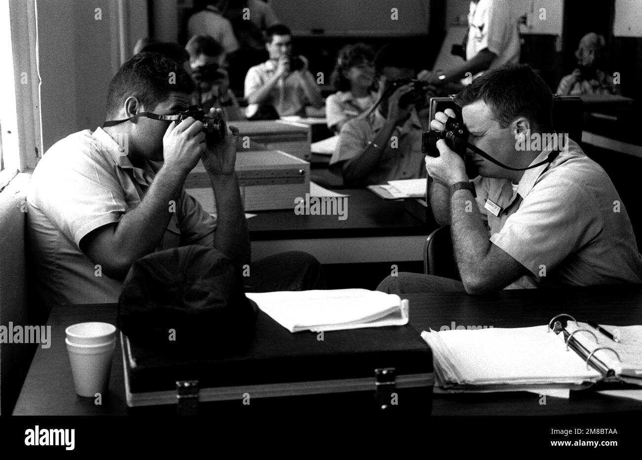 Two students at the naval Schools of Photography practice focusing ...