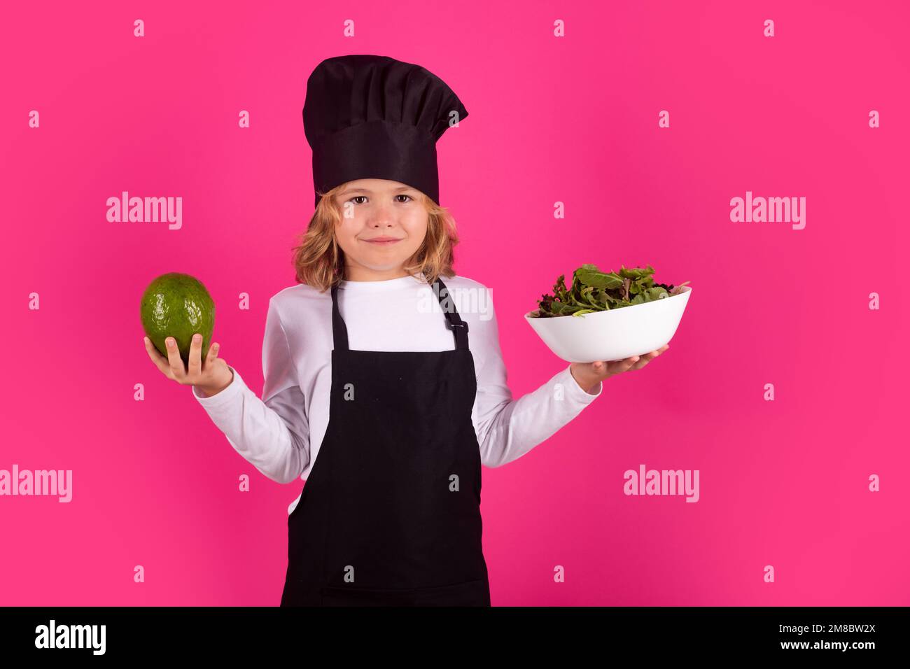 Kid cook with avocado and vegetable. Kid in cooker uniform and chef hat ...