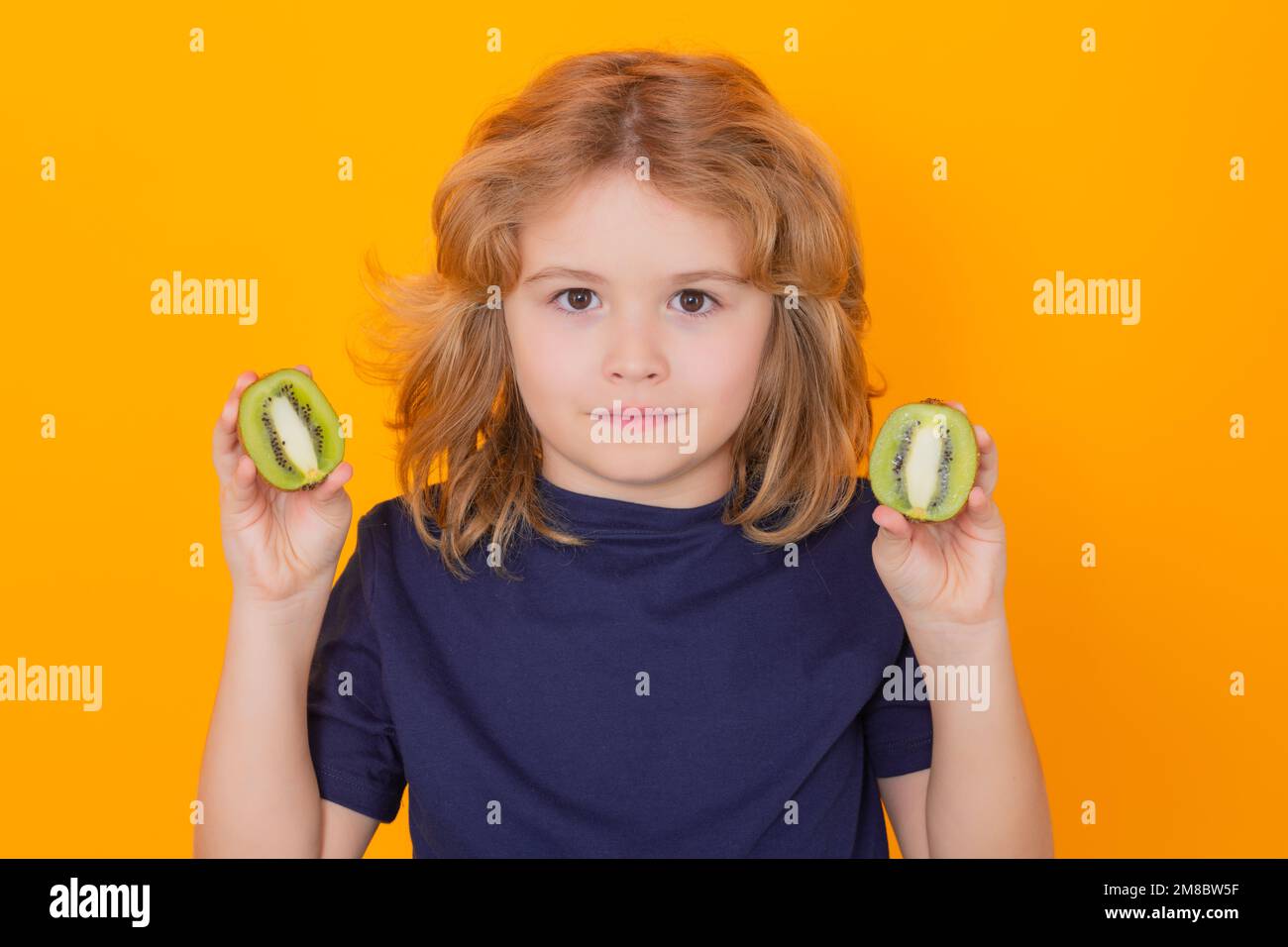 Kids face with fruits. Child hold kiwi in studio. Kiwi fruit. Studio ...