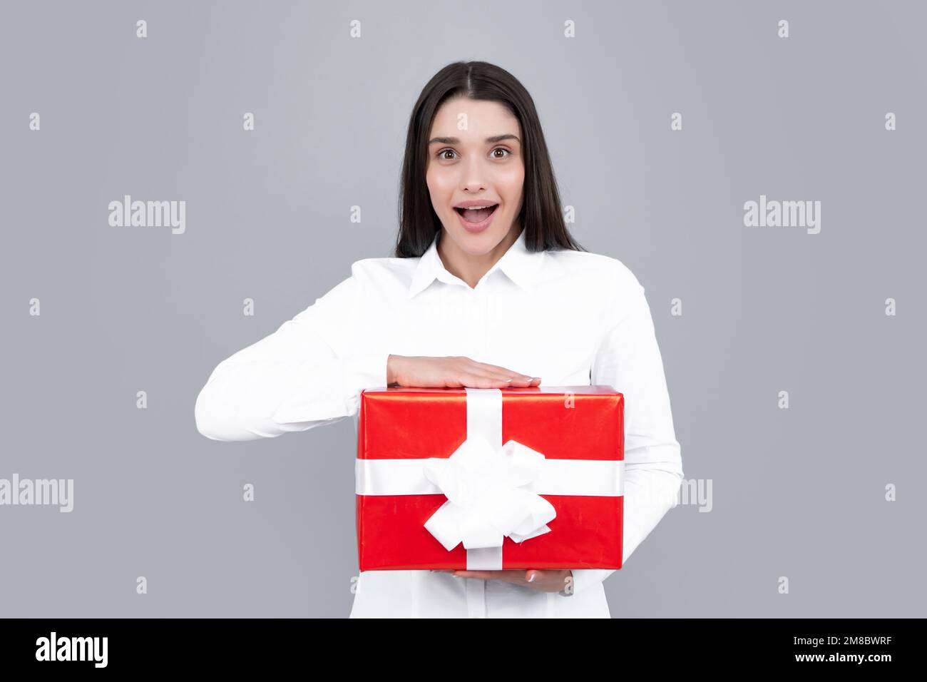 Portrait of a happy smiling girl holding present box and isolated over ...