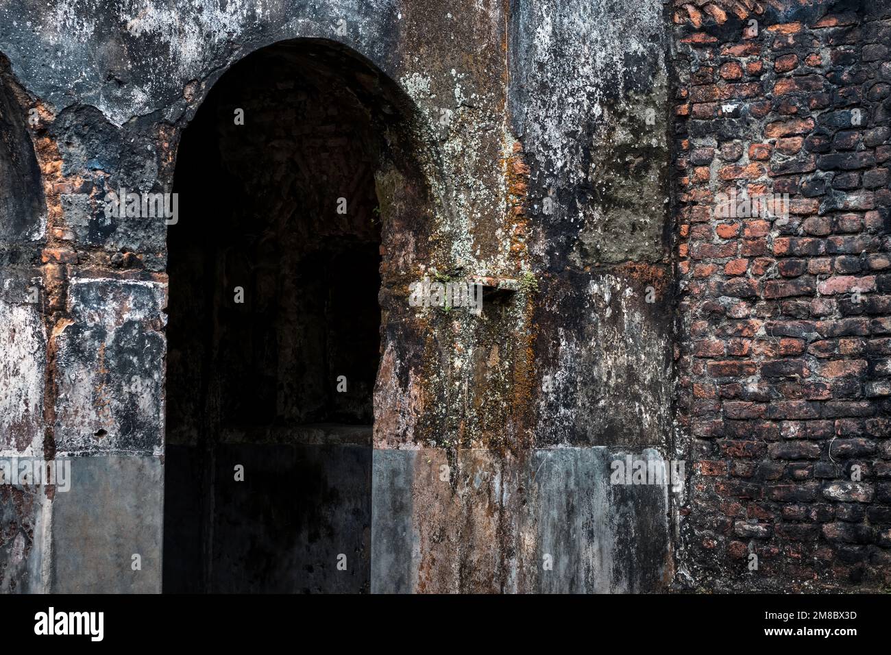 Abandoned door of an ancient building with a damaged rustic brick wall ...