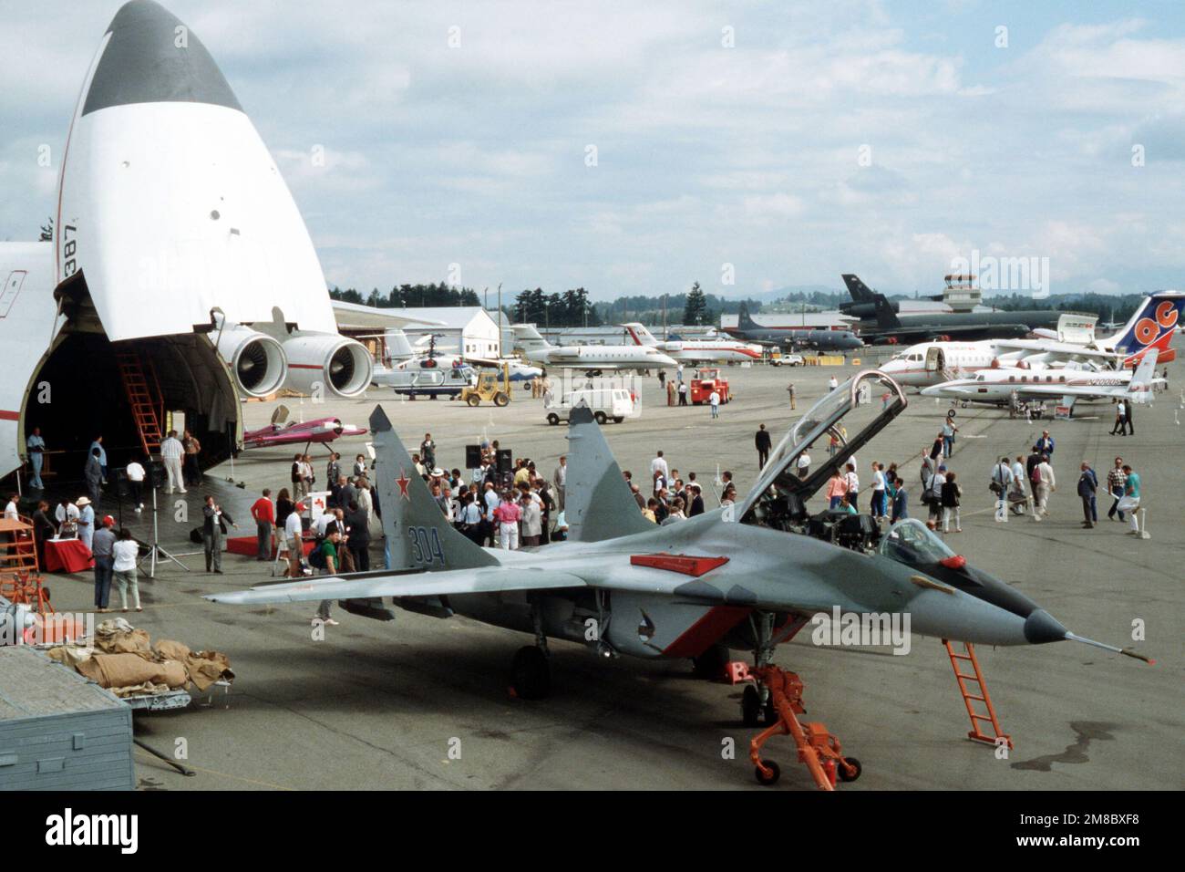 The crowd views a MiG-29 Fulcrum aircraft, foreground, and an An-225 ...