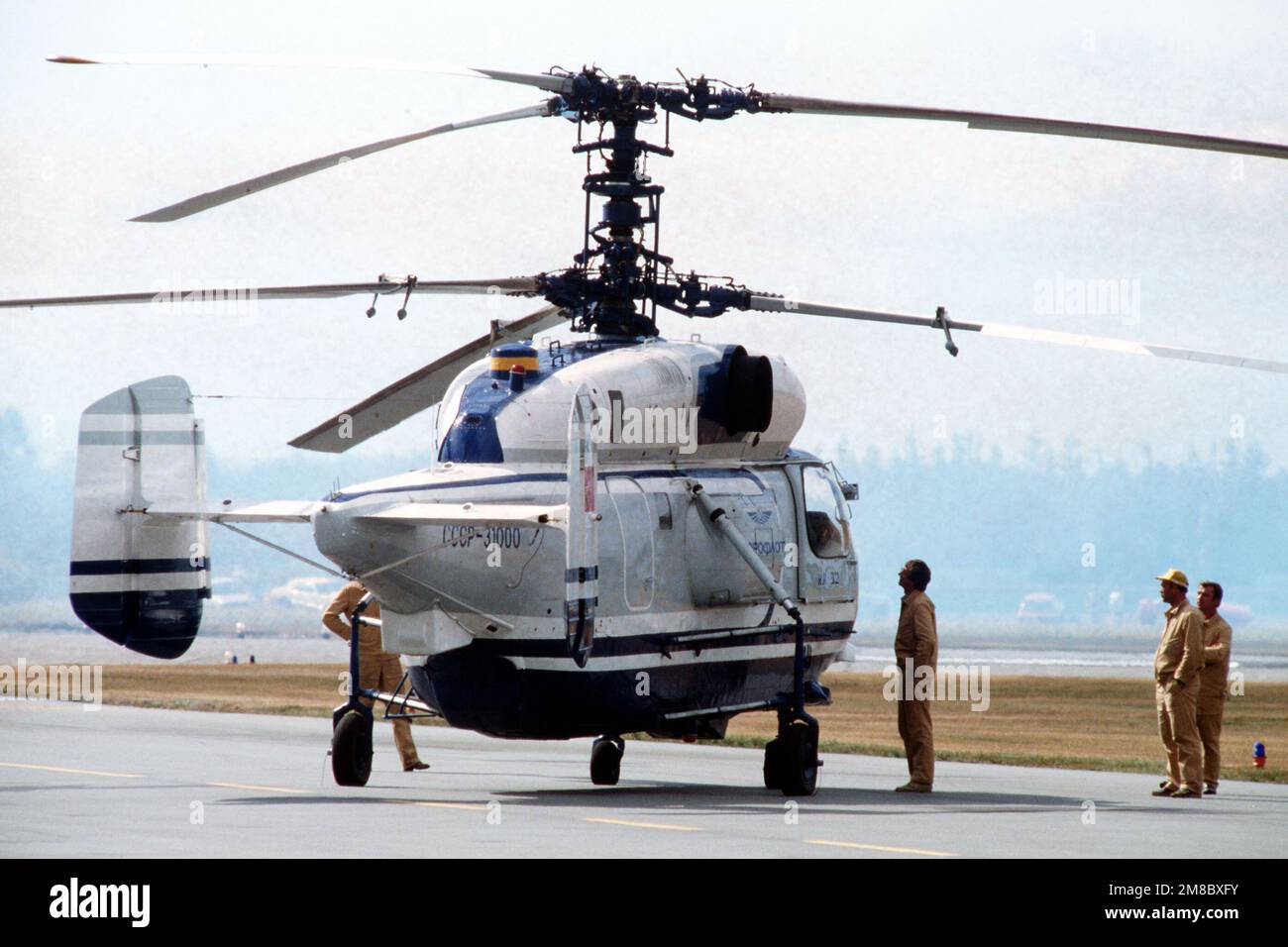 Ground crewmen look over a Soviet Ka-32 Helix helicopter during Airshow ...