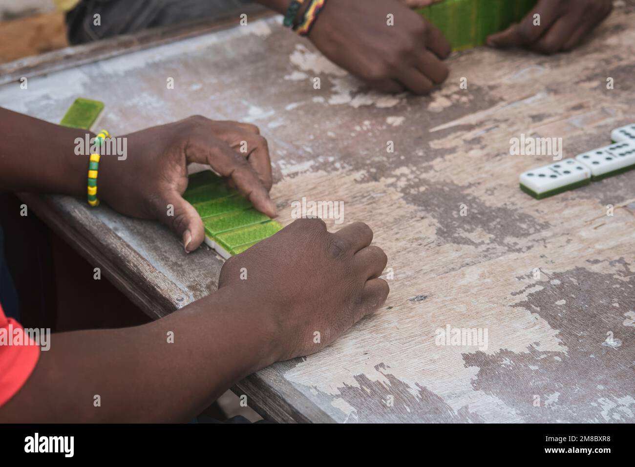 A closeup of black hands playing dominoes in the neighborhood of La ...