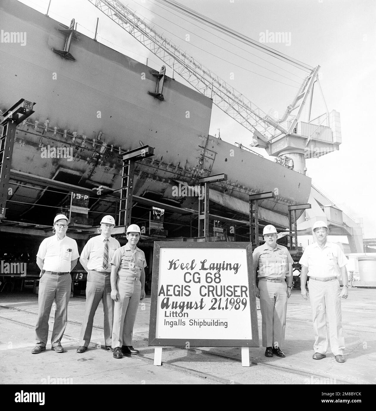 Representatives of Ingalls Shipbuilding and the U.S. Navy stand by a ...