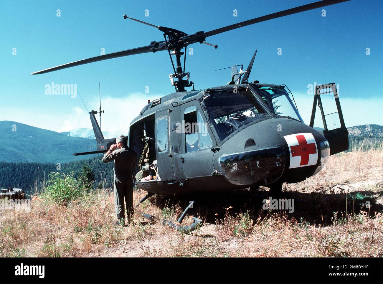 The crew of an Army National Guard UH-1 Iroquois helicopter waits for ...