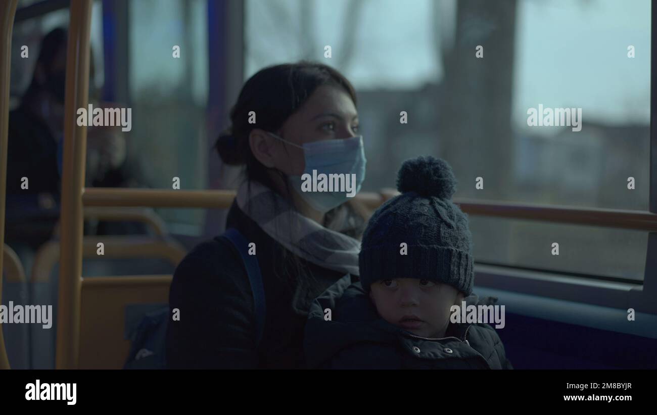 Mother wearing covid-19 face mask with toddler inside bus public ...