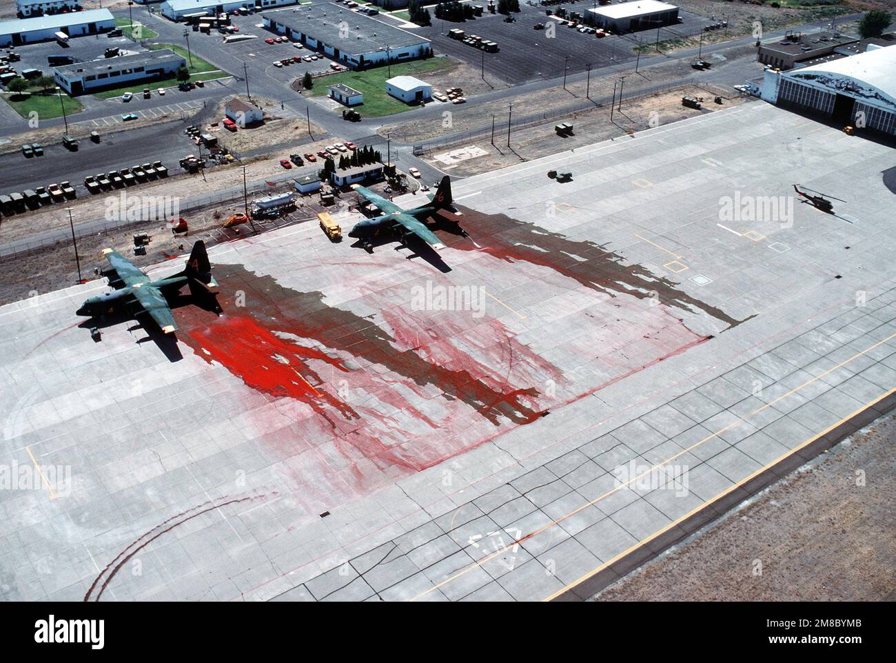 Flame retardant chemicals stain the flight line near two C-130 Hercules ...