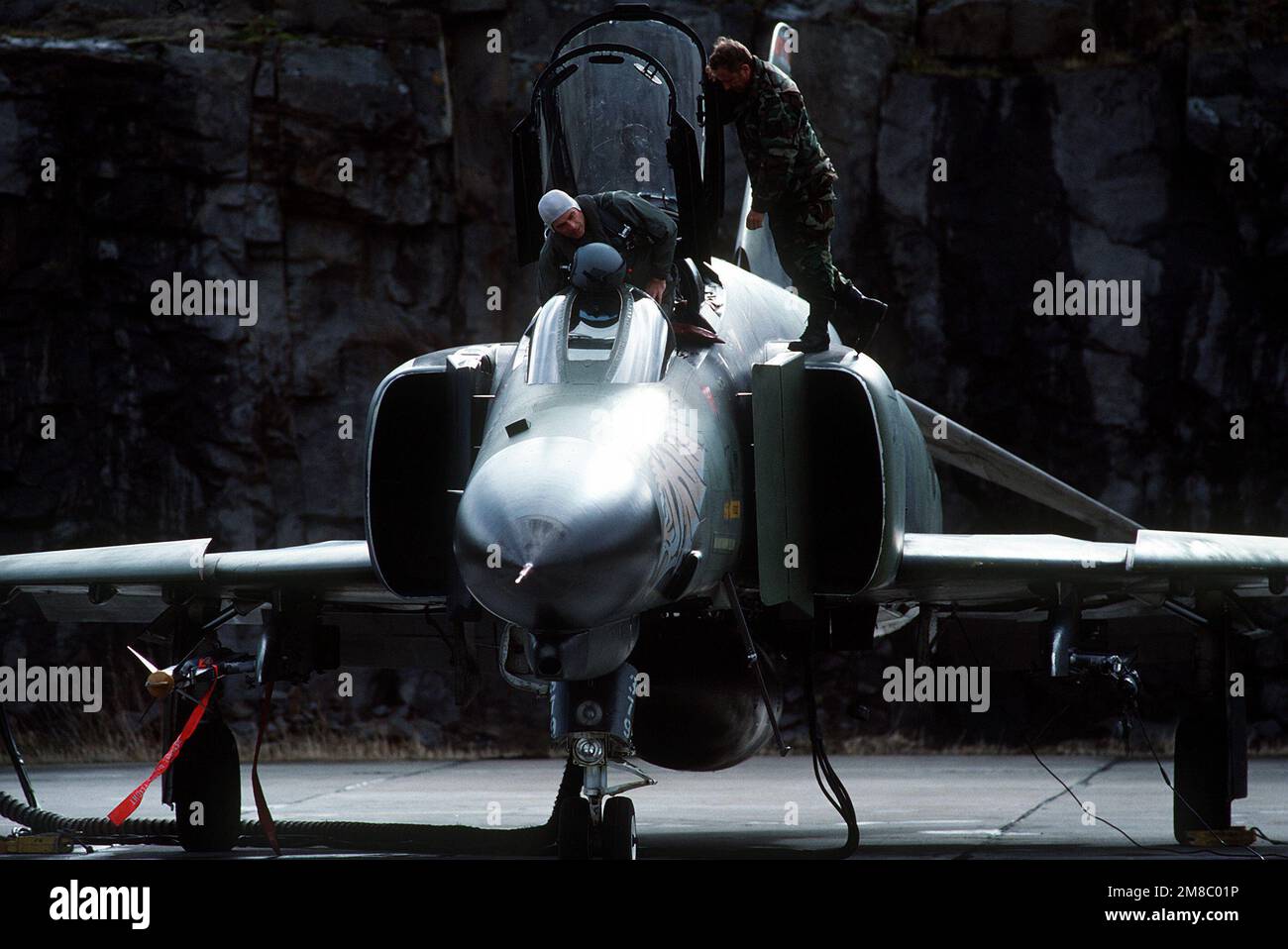 The pilot and crew chief of an F-4E Phantom II aircraft perform a ...