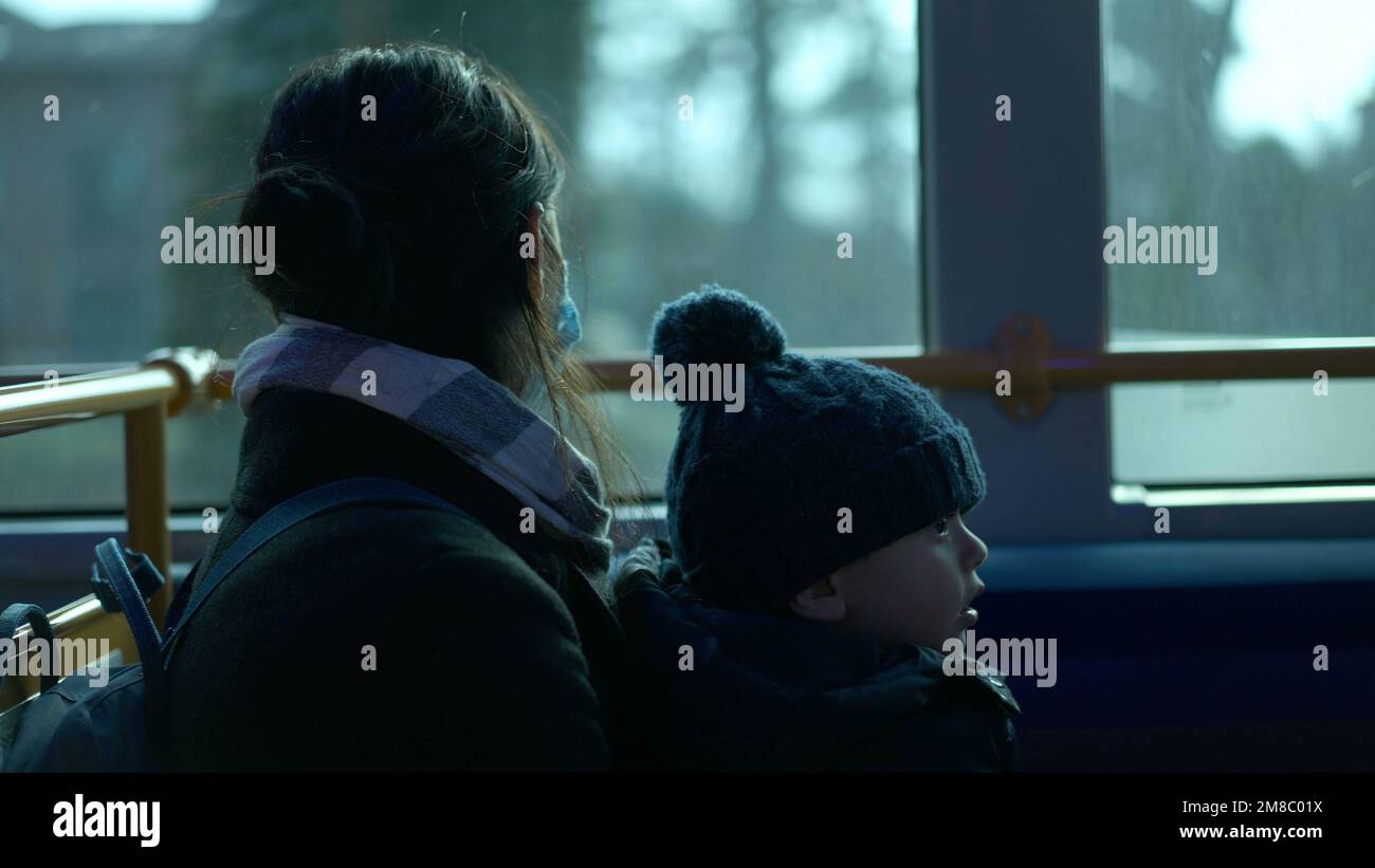 Mother riding public bus transportation while holding baby toddler in ...
