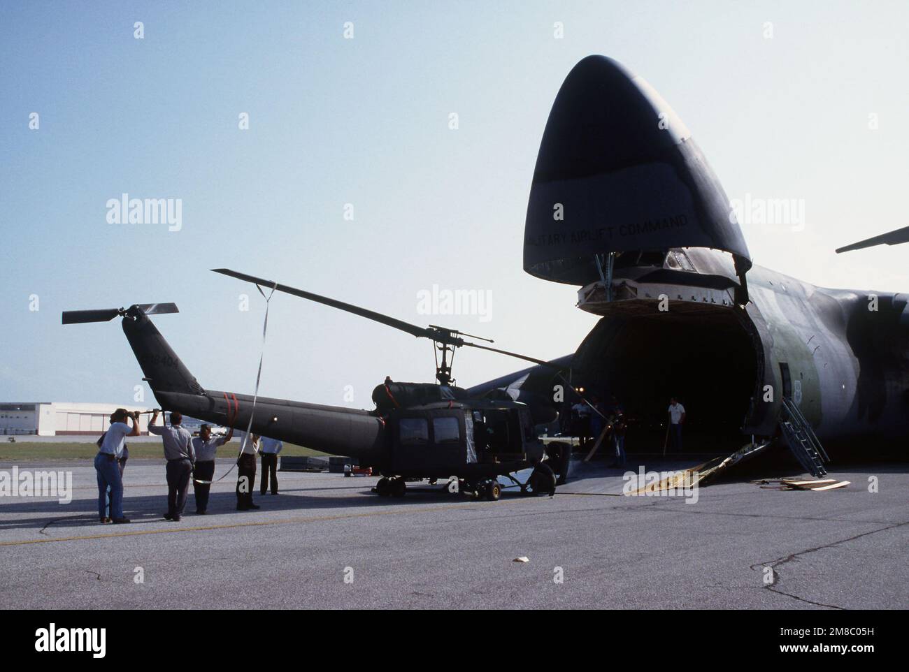Civilian workers and U.S. military personnel prepare one of several UH ...