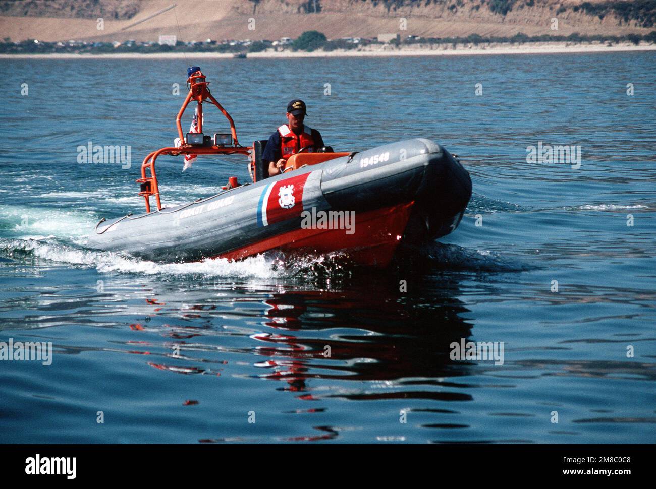 A member of the US Coast Guard patrols in an inflatable boat during a ...