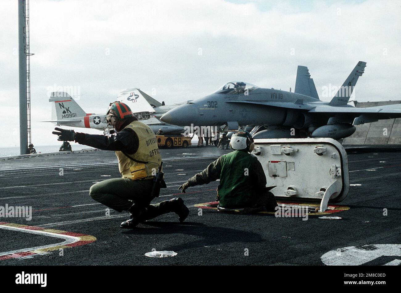 A catapult officer signals for the launch of a Strike Fighter Squadron ...