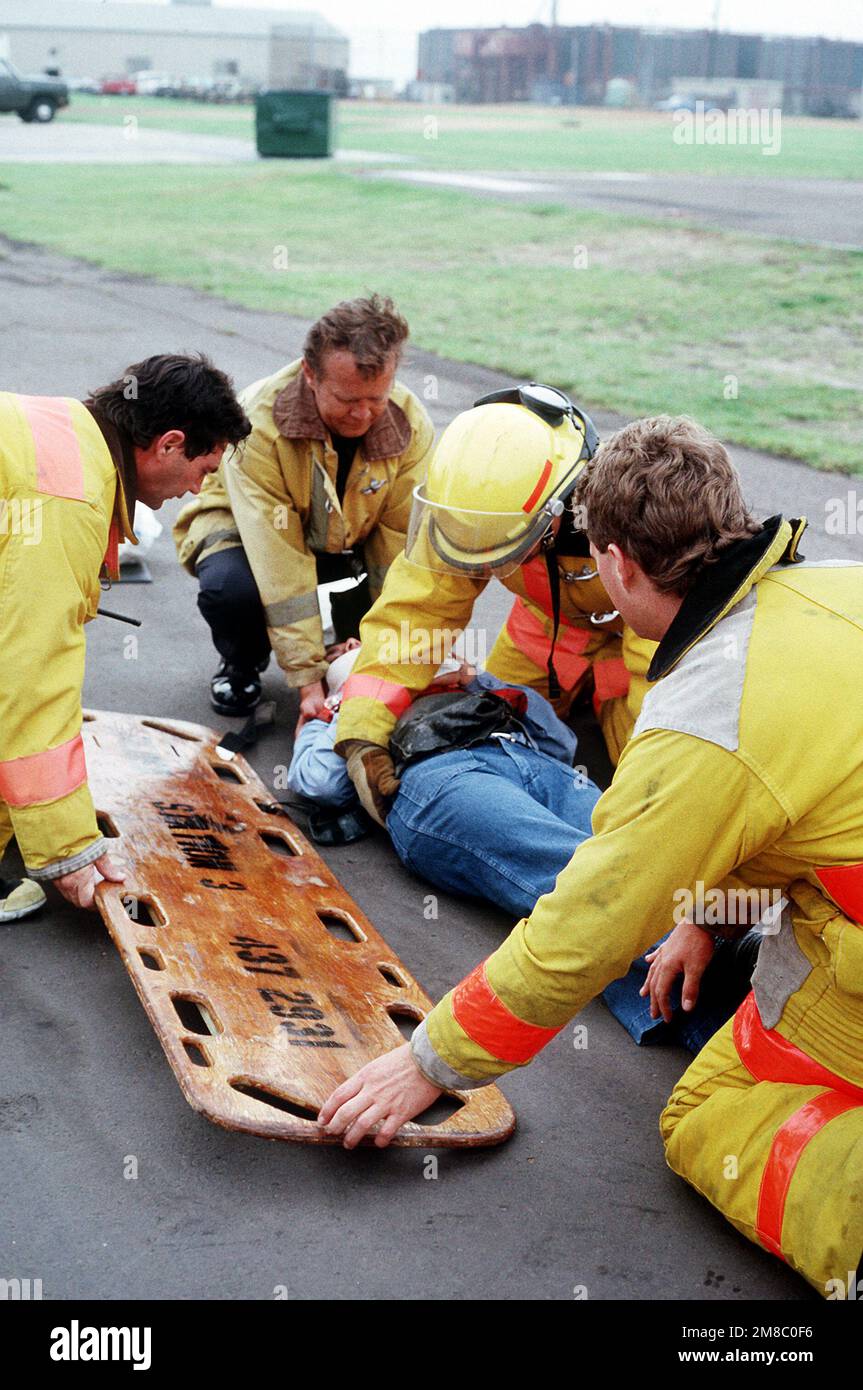 Emergency personnel practice medical evacuation techniques with a back ...