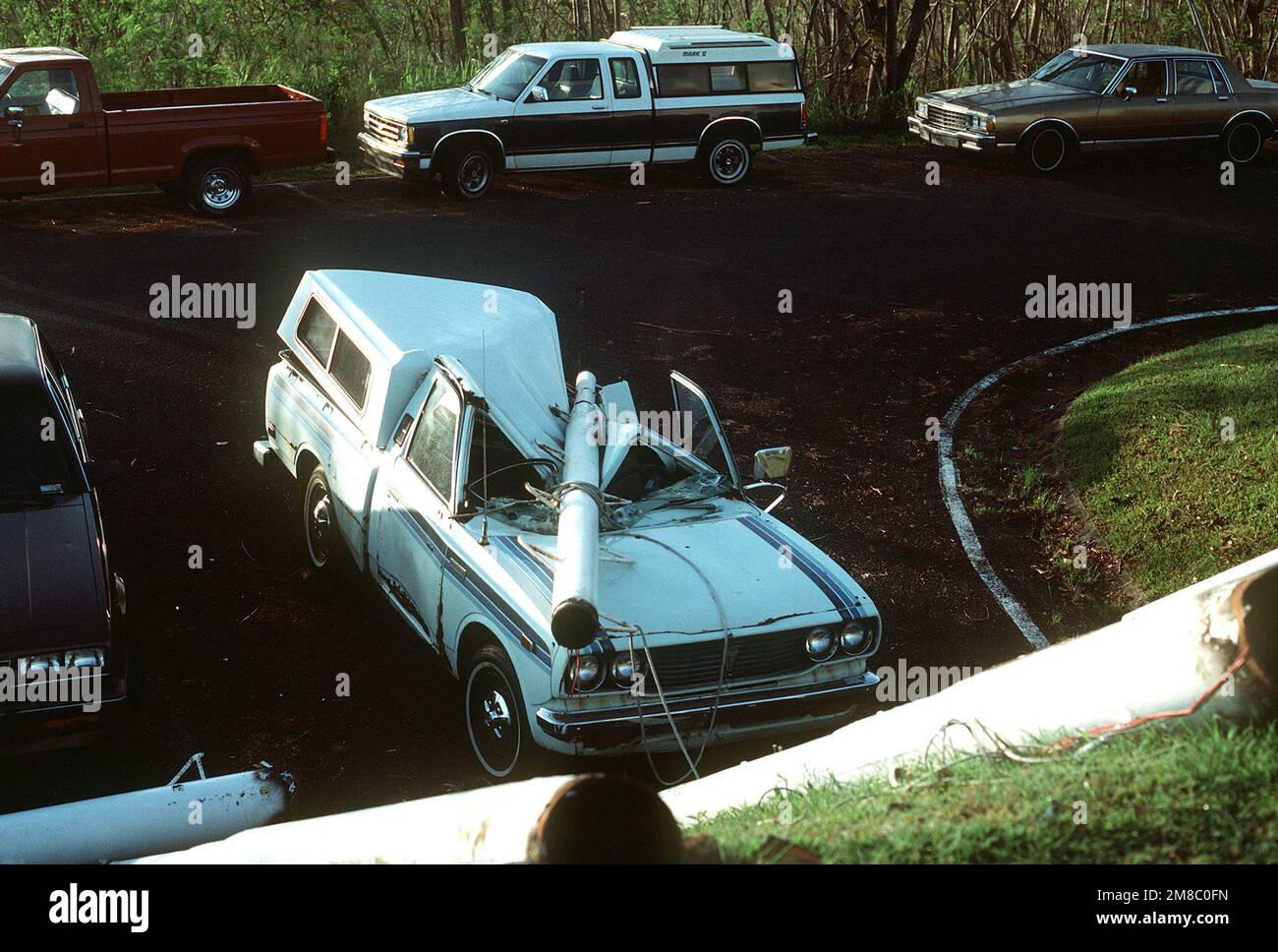 A pickup truck sustains extensive damage from an uprooted, metal pole ...