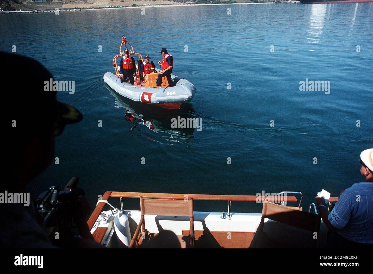 Coast Guardsmen in an inflatable boat practice interdiction of a small ...