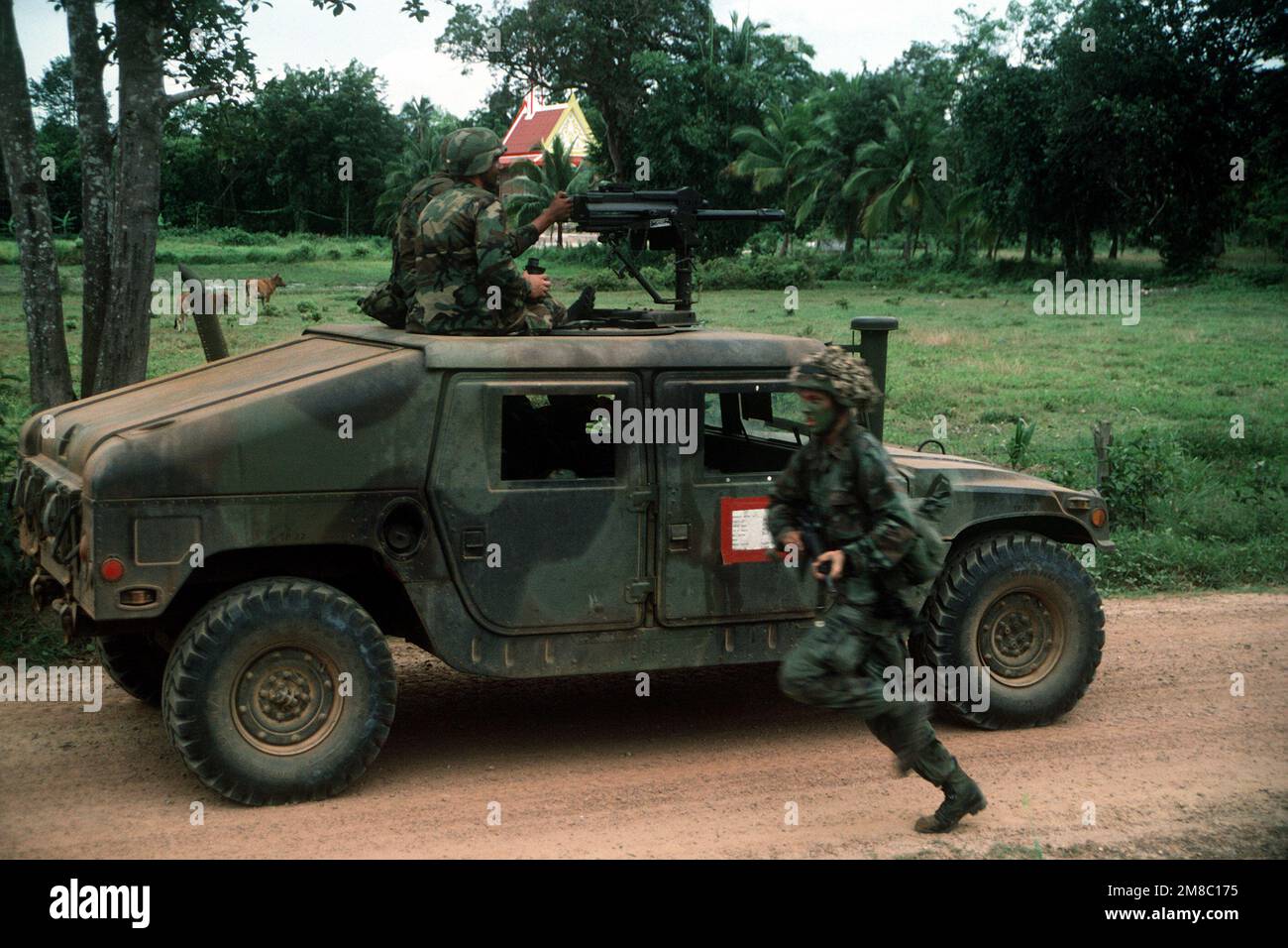 A member of the 11th Marine Expeditionary Unit (11th MEU) runs past two ...