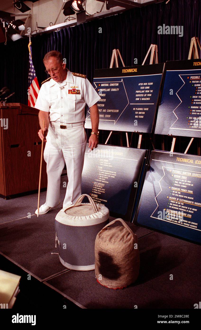 Rear Adm. Richard D. Milligan points to two powder bags during a ...