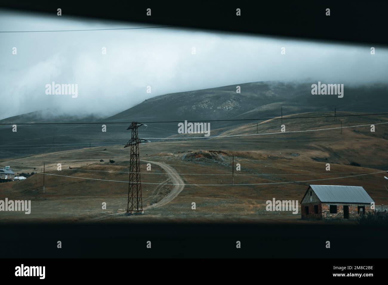 The isolated rural area with small house and electrical tower visible ...