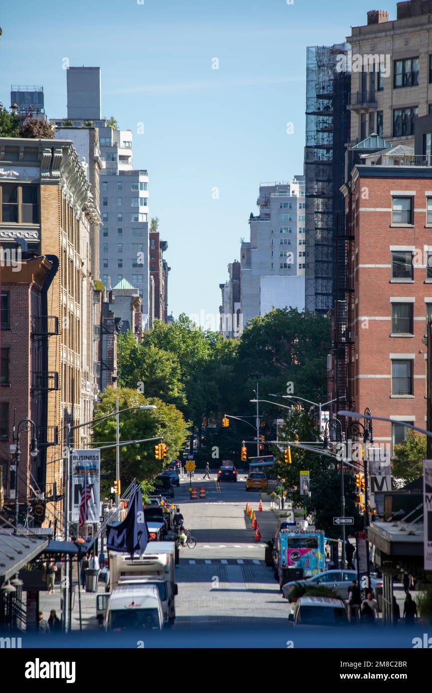 A street with parked cars between trees and buildings Stock Photo - Alamy