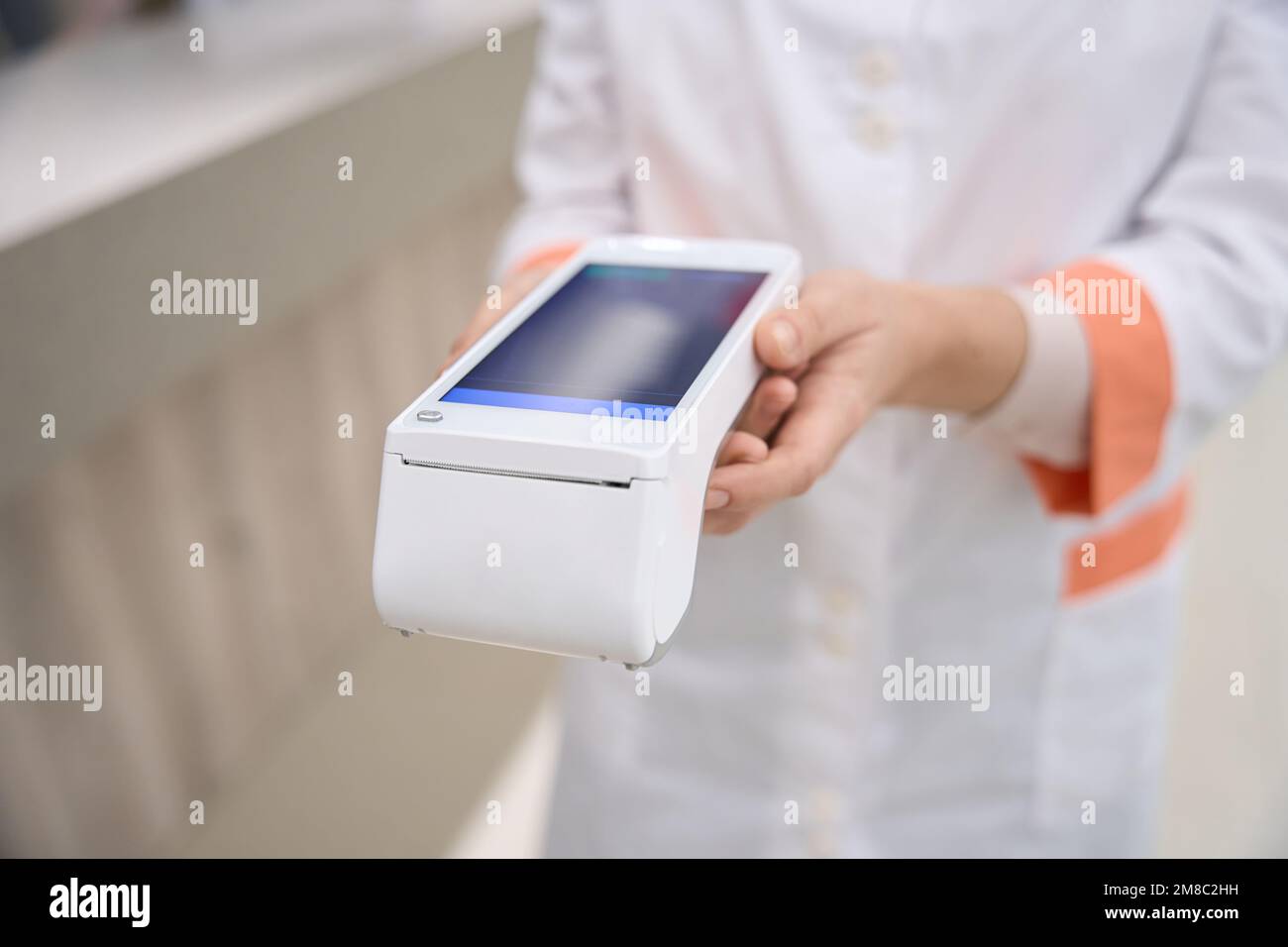 Female medical worker holds terminal for paying for medical services ...