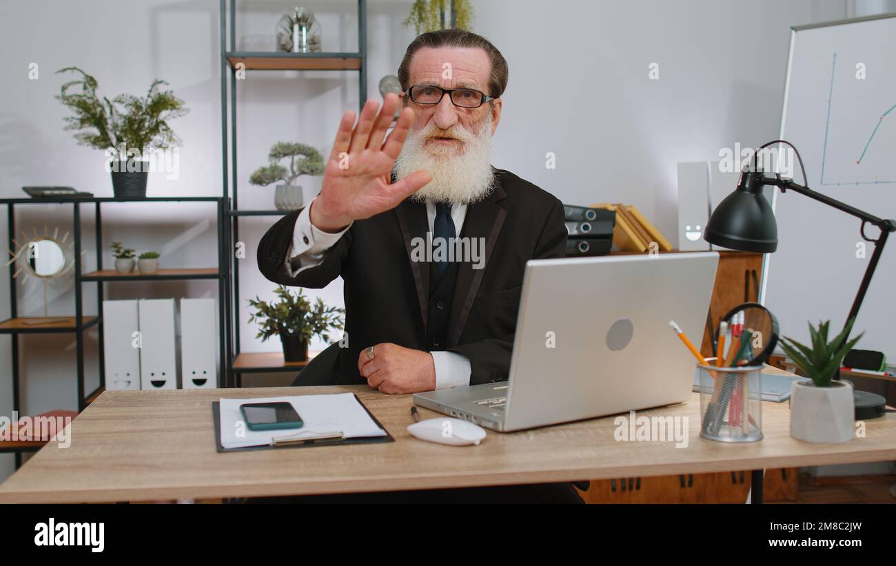 Stop. Senior businessman working on laptop, warning of finish ...