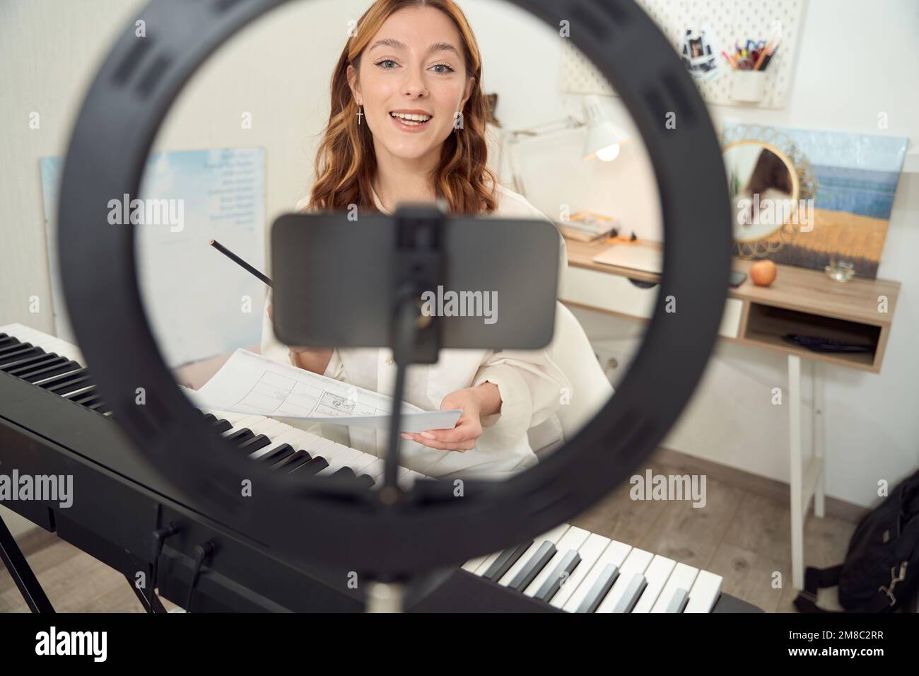 Joyous female musician sharing her songwriting skills with online ...